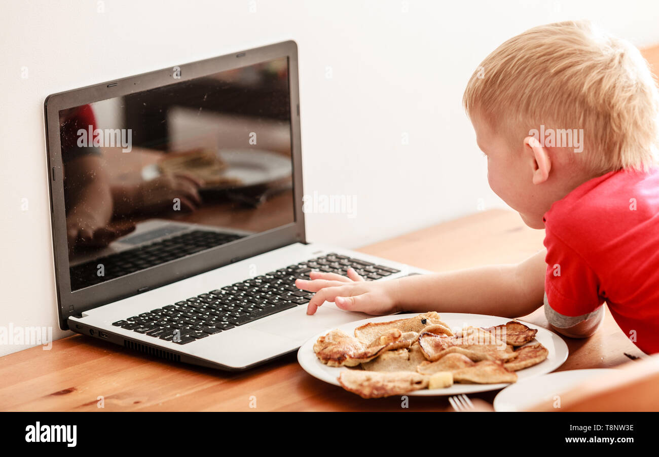 Children, technology and home concept - little boy child eating meal ...