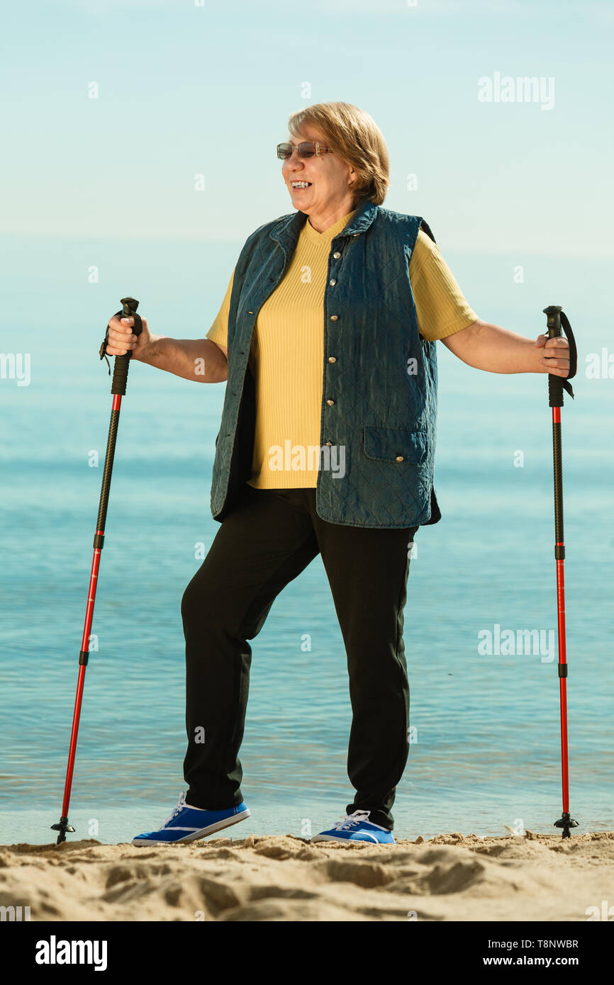 Healthy lifestyle in old age. Senior woman practicing nordic walking on ...