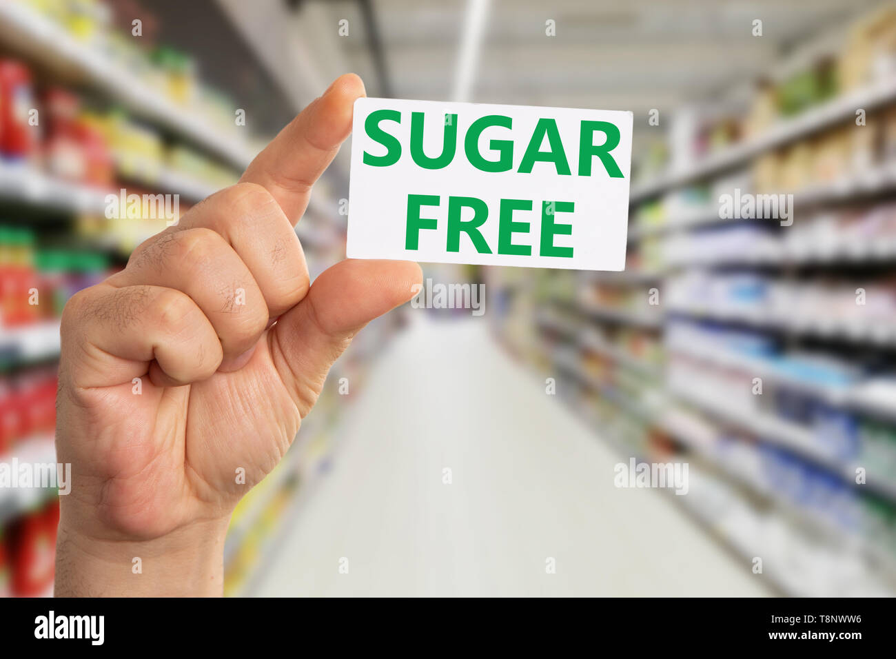 Closeup of green sugar free text on white carton card held by ...