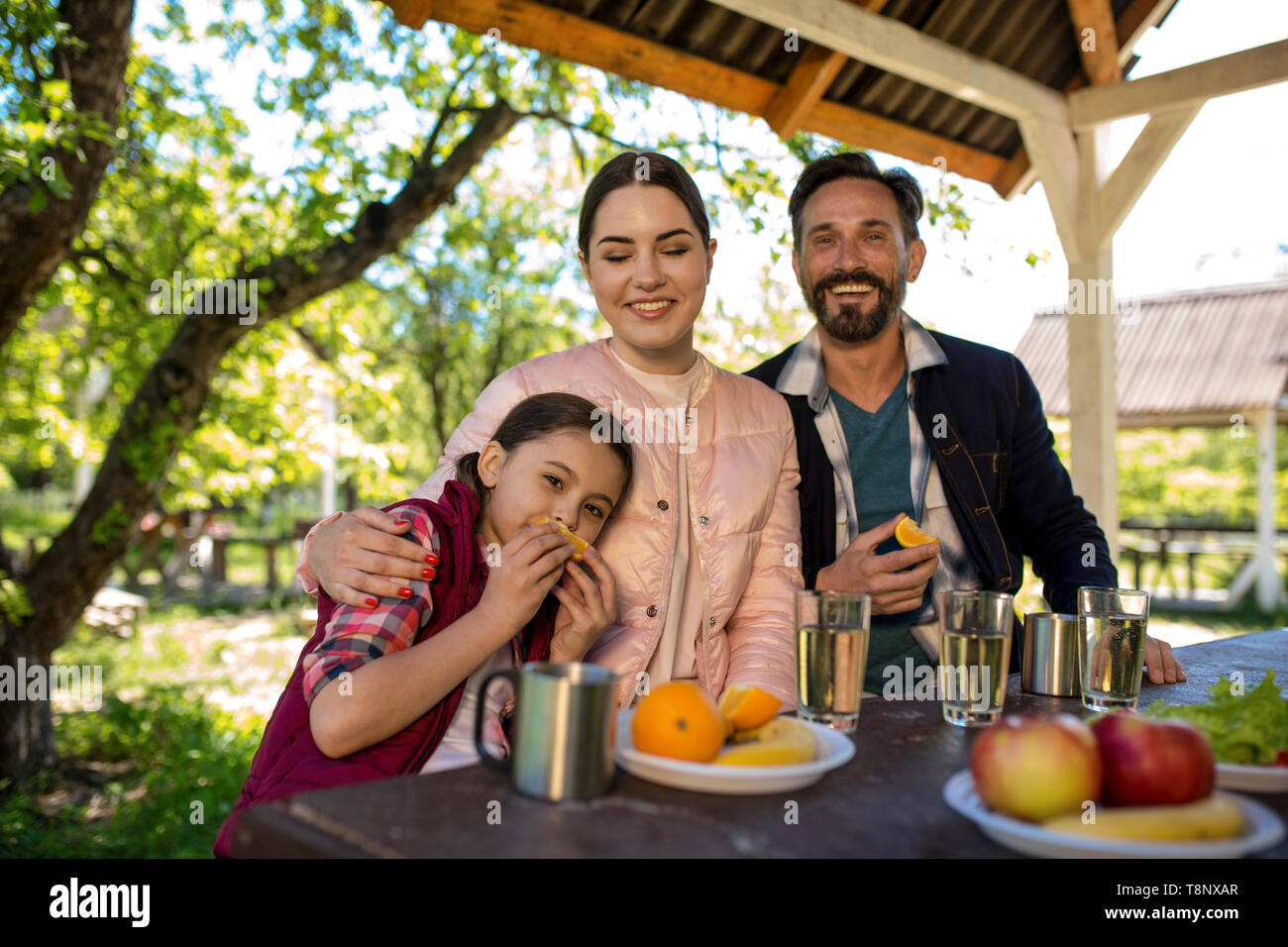Happy Family Are Sitting By The Table In The Park. Plates With ...