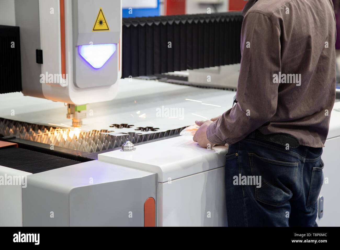 Industrial worker operate CNC laser cutting machine cutting metal sheet ...