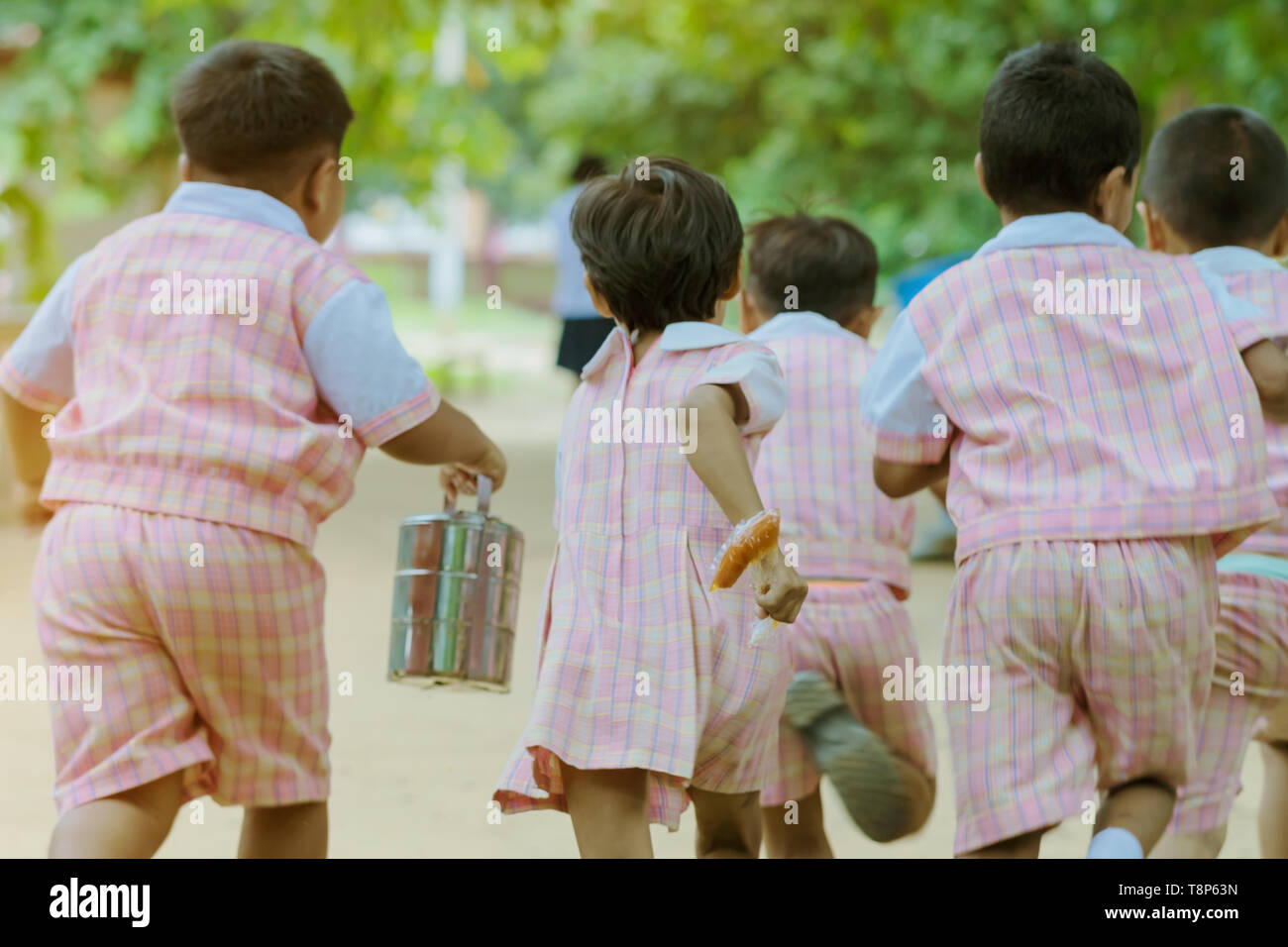 Back view of Kindergarten students run back to the classroom after ...
