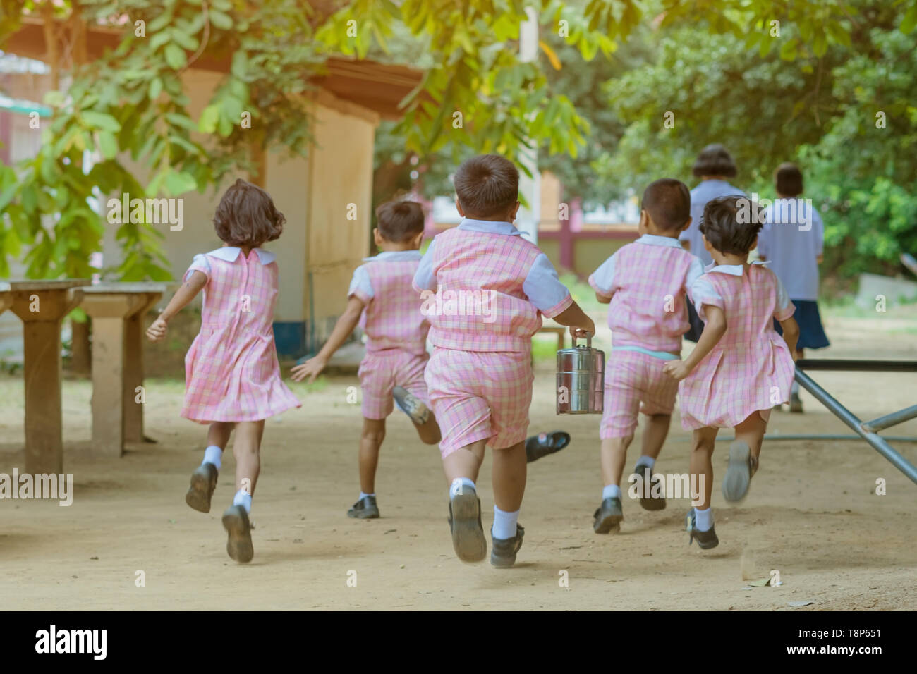 Back view of Kindergarten students run back to the classroom after ...