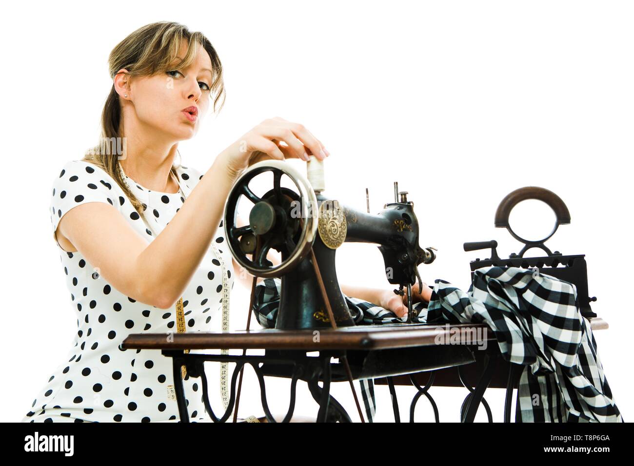 Woman dressmaker pin up style using antique sewing manual machine ...
