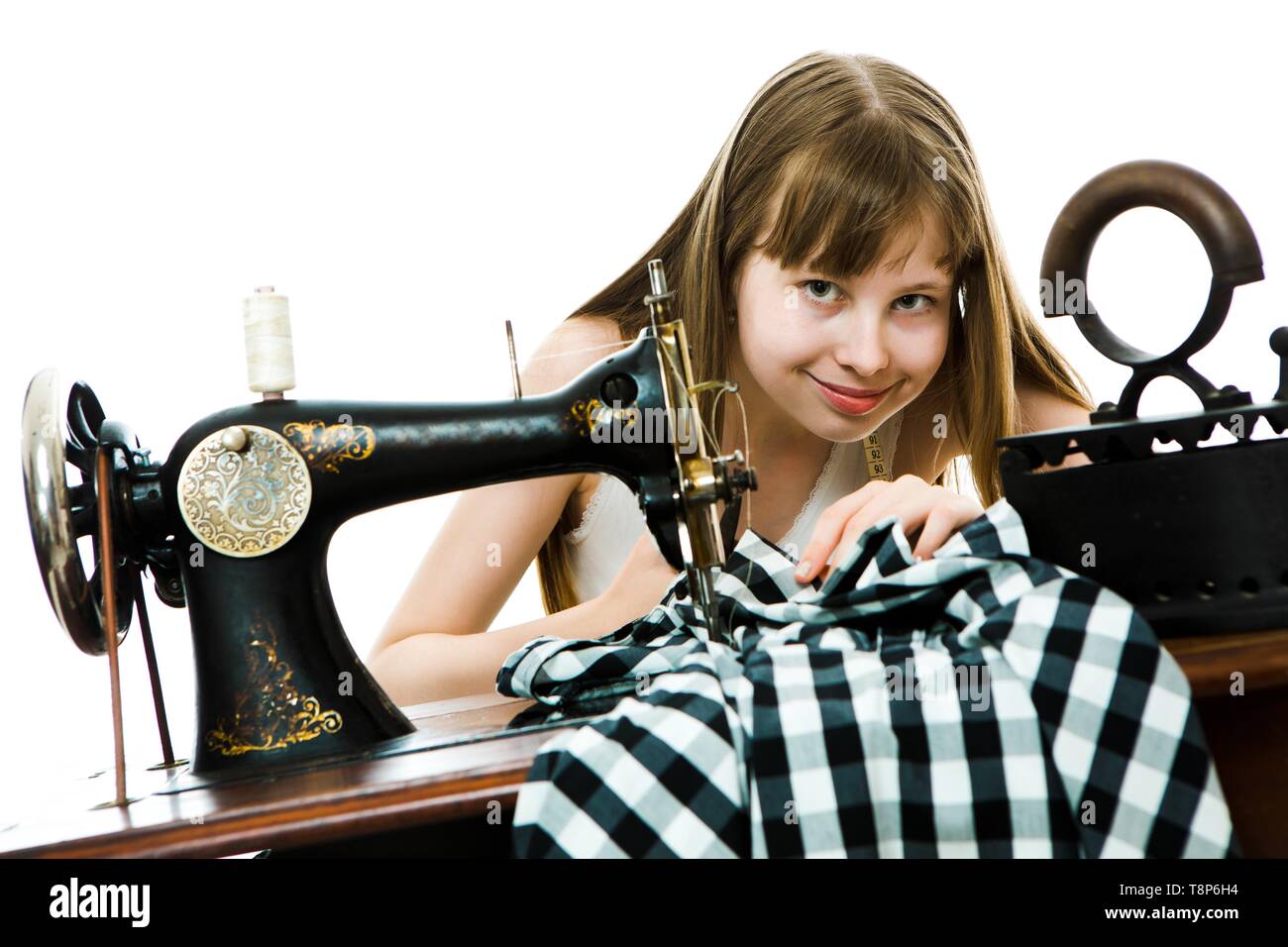 Teenaged girl tailoress use manual sawing machine to sew her dress ...