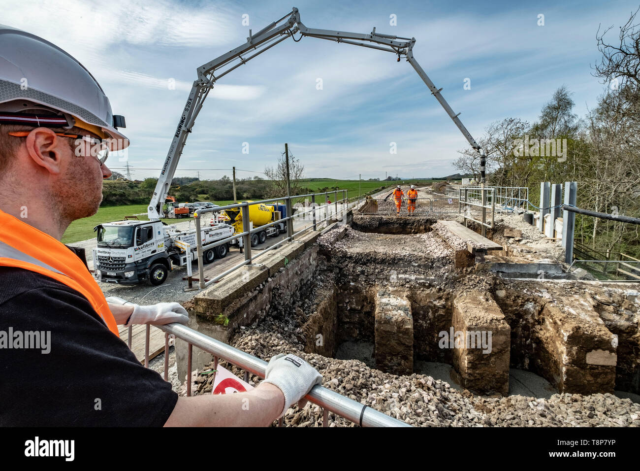 Railway workers constructing railway and lifting rail bridge into place ...