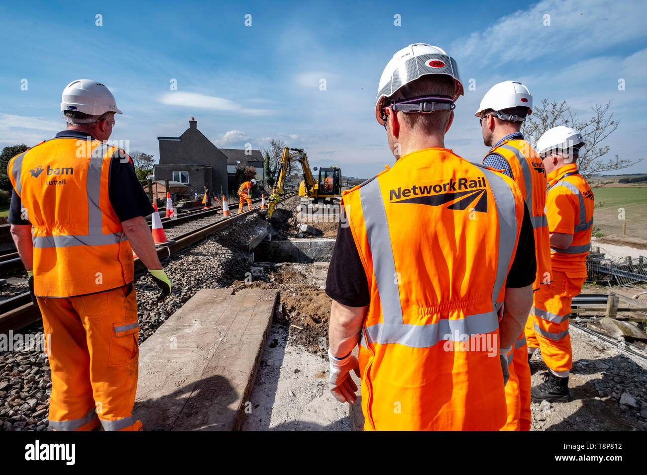 Railway workers constructing railway and lifting rail bridge into place ...