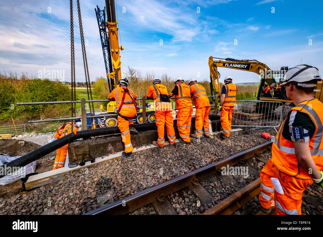 Railway workers constructing railway and lifting rail bridge into place ...