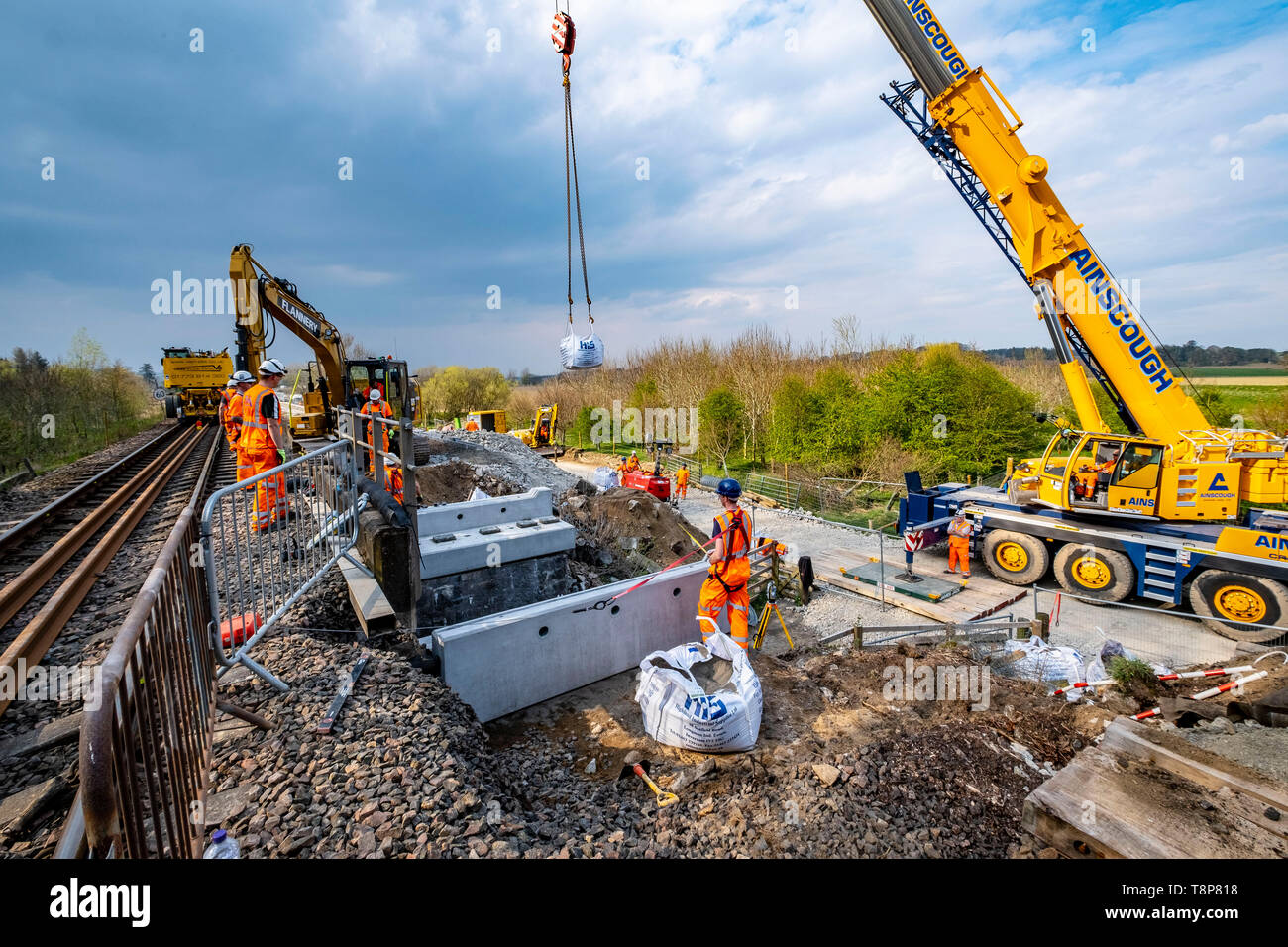 Railway workers constructing railway and lifting rail bridge into place ...