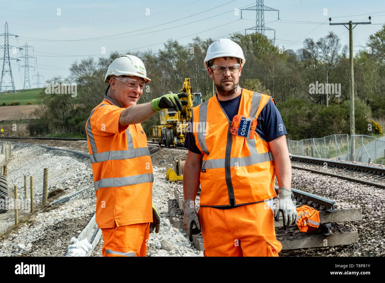 Railway workers constructing railway and lifting rail bridge into place ...