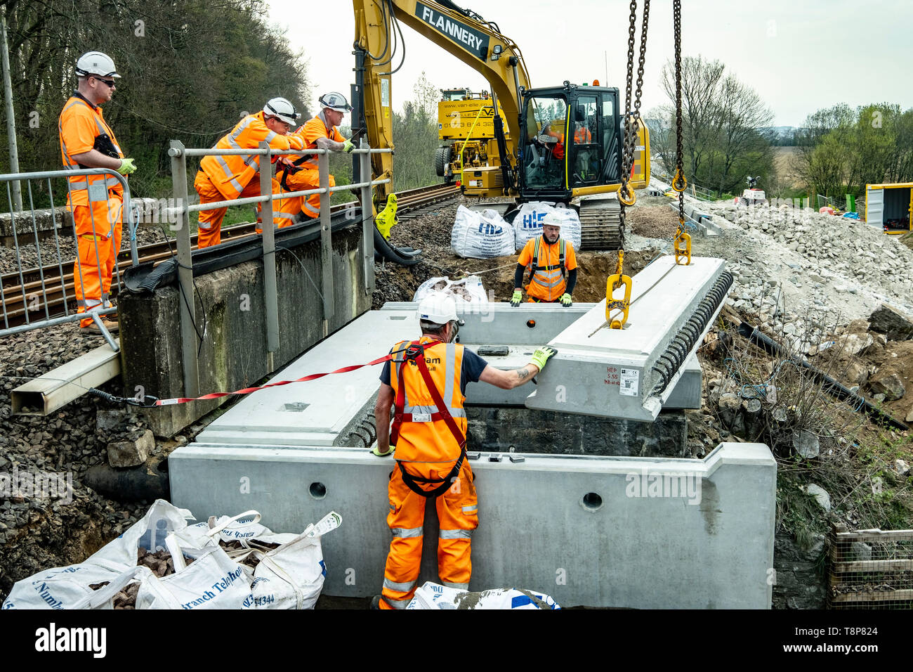 Railway workers constructing railway and lifting rail bridge into place ...