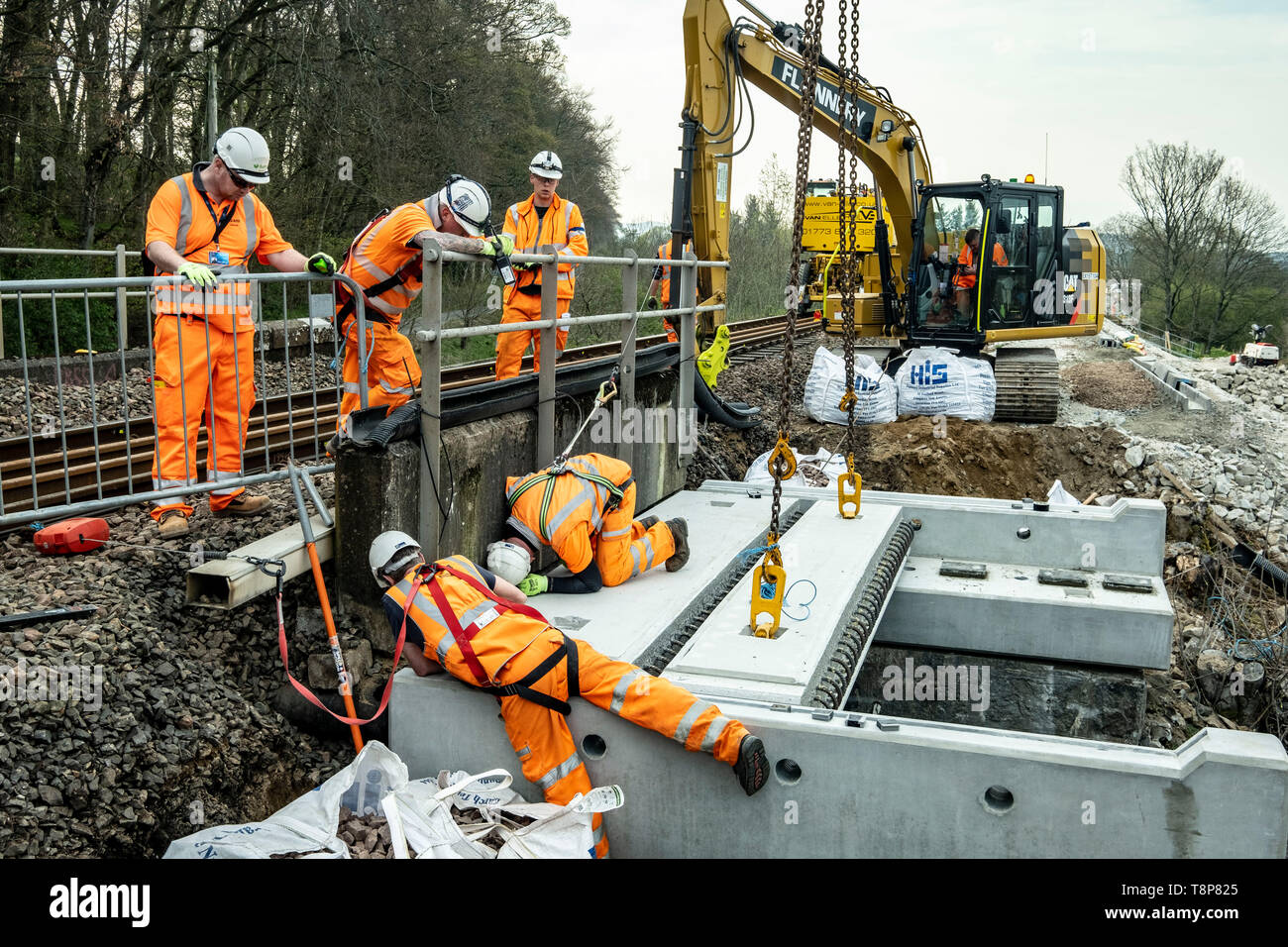 Railway workers constructing railway and lifting rail bridge into place ...