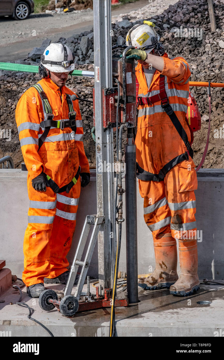 Railway workers constructing railway and lifting rail bridge into place ...