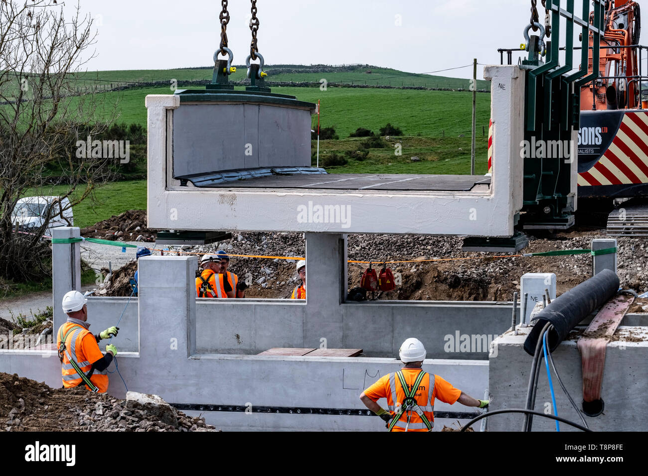 Railway workers constructing railway and lifting rail bridge into place ...