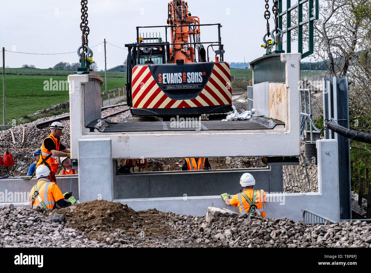 Railway workers constructing railway and lifting rail bridge into place ...