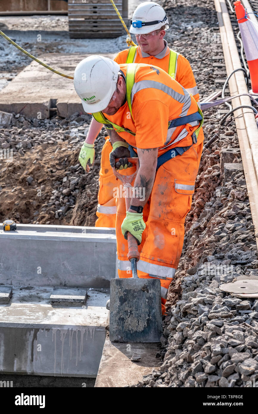 Railway workers constructing railway and lifting rail bridge into place ...