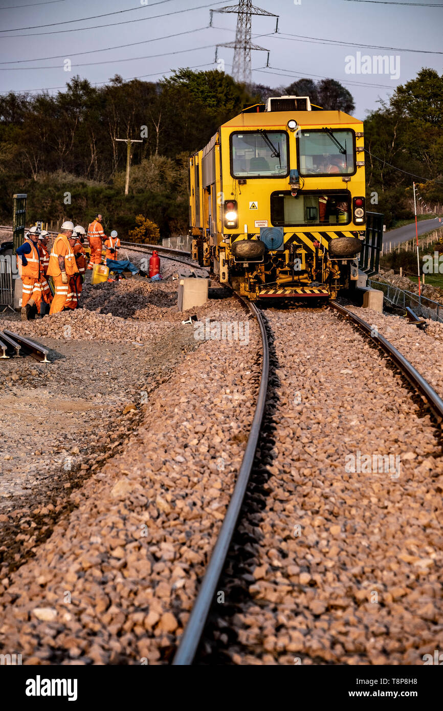 Railway workers constructing railway and lifting rail bridge into place ...