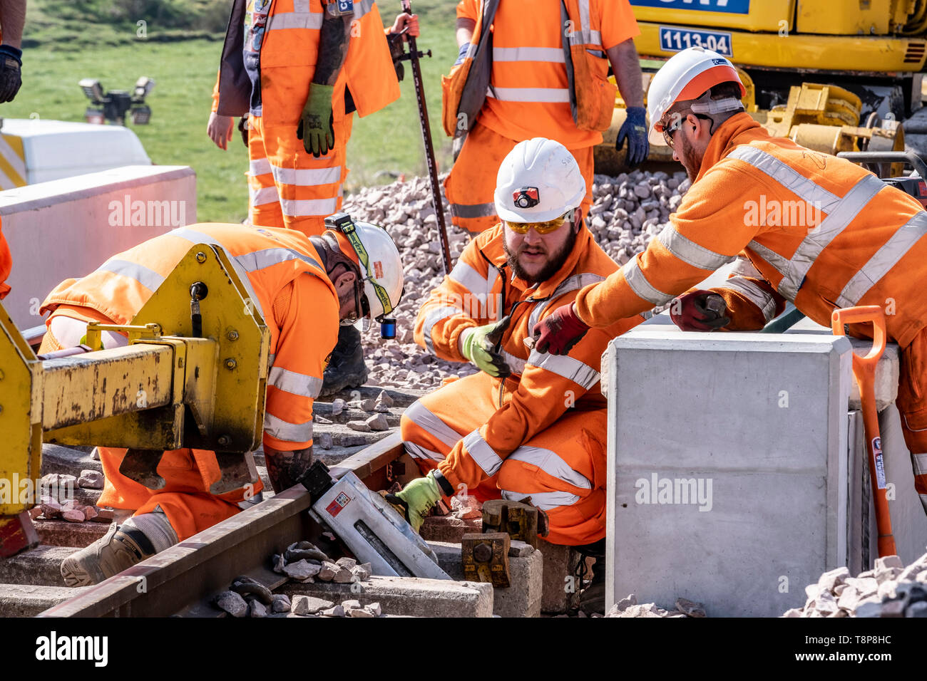 Railway workers constructing railway and lifting rail bridge into place ...