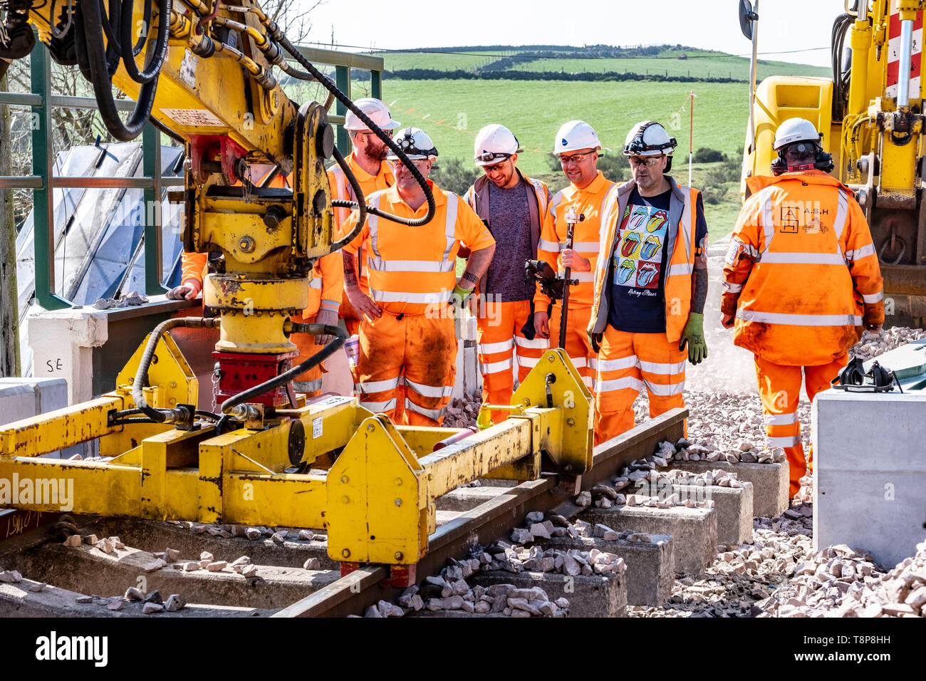 Railway workers constructing railway and lifting rail bridge into place ...