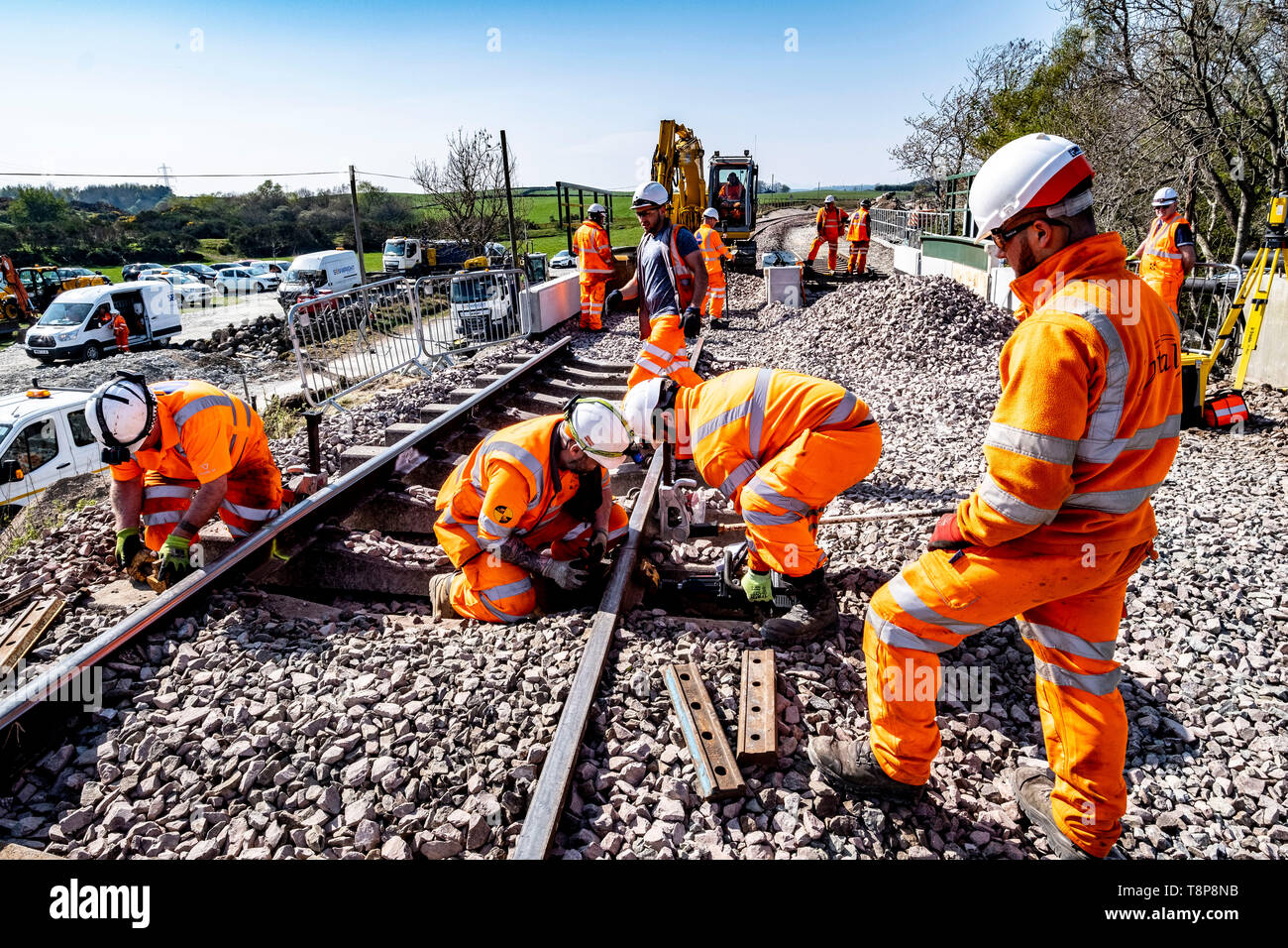 Railway workers constructing railway and lifting rail bridge into place ...