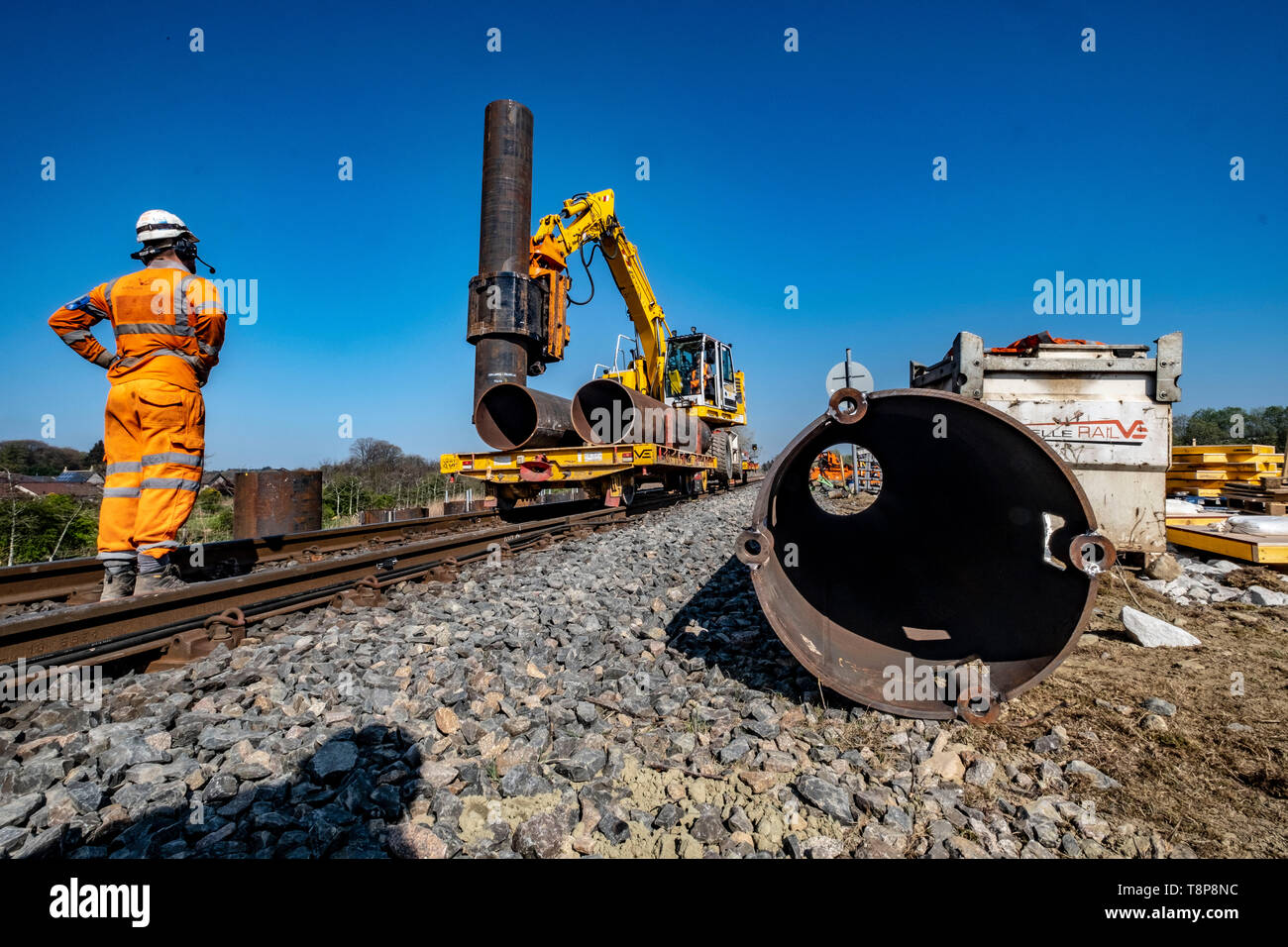 Railway workers constructing railway and lifting rail bridge into place ...