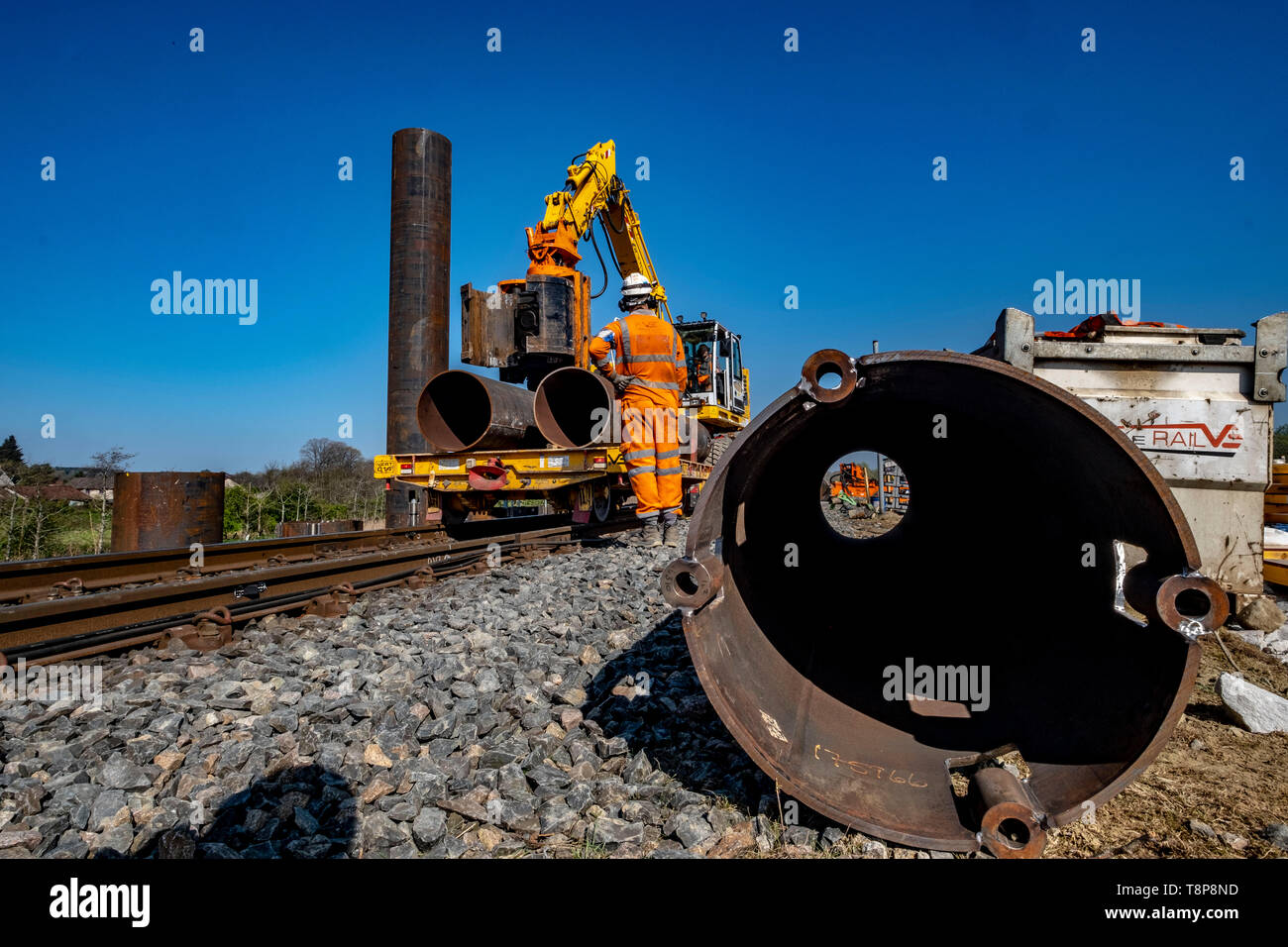 Railway workers constructing railway and lifting rail bridge into place ...