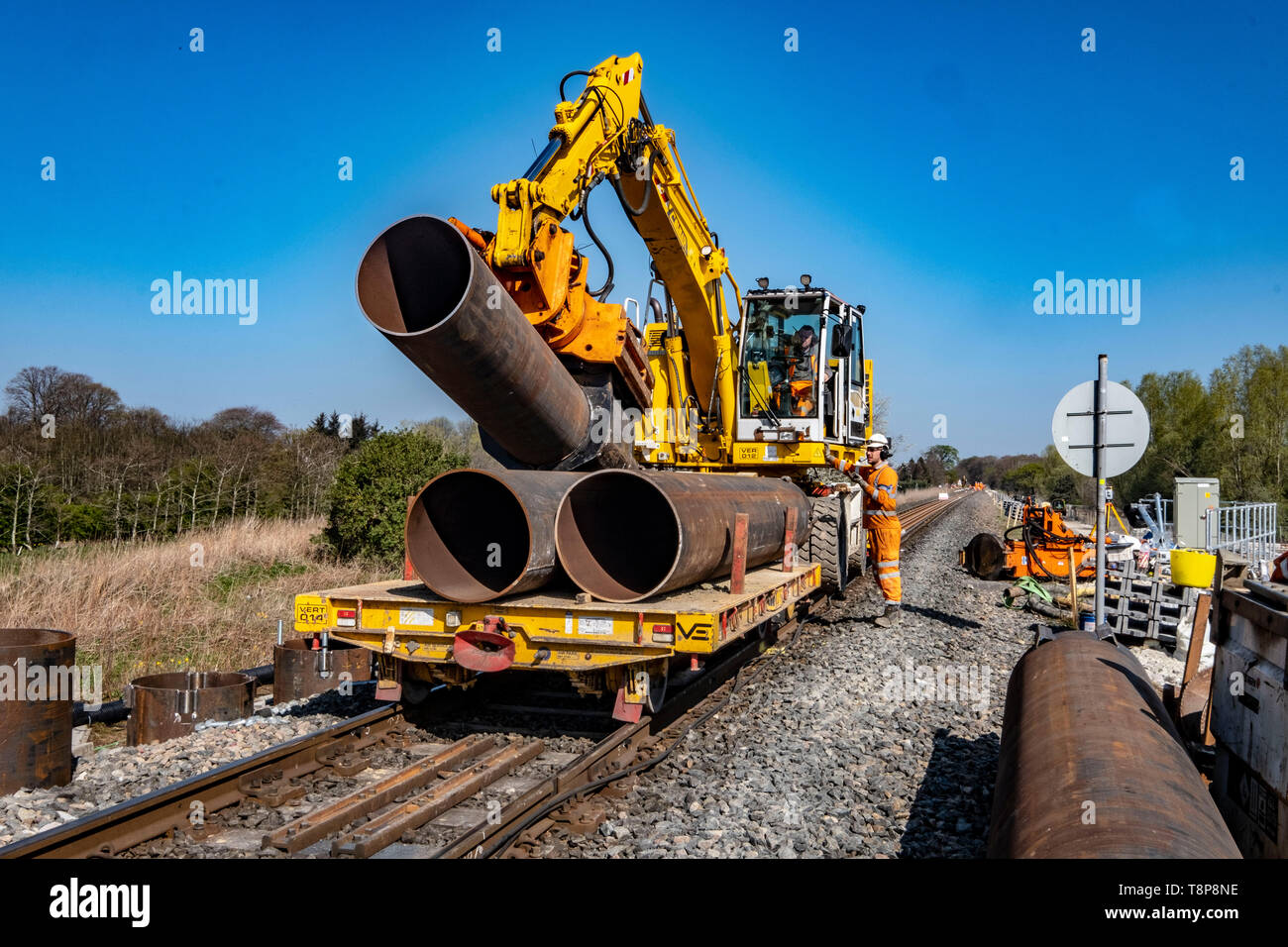 Railway workers constructing railway and lifting rail bridge into place ...