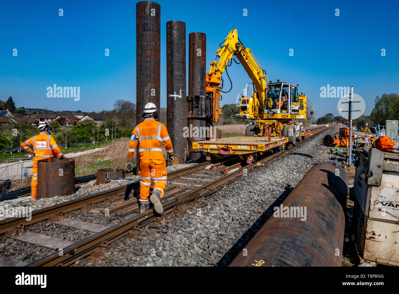 Railway workers constructing railway and lifting rail bridge into place ...