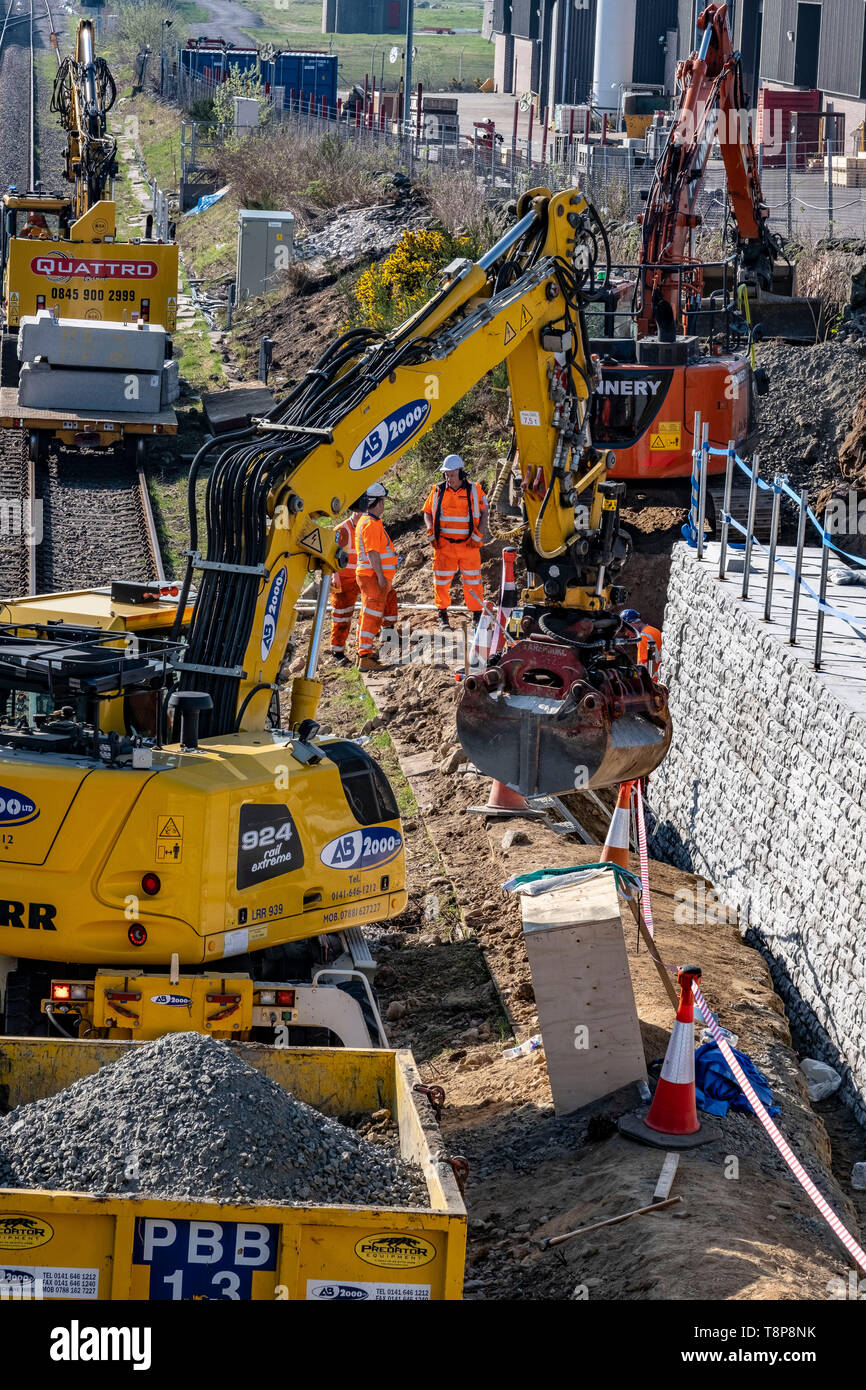 Railway workers constructing railway and lifting rail bridge into place ...