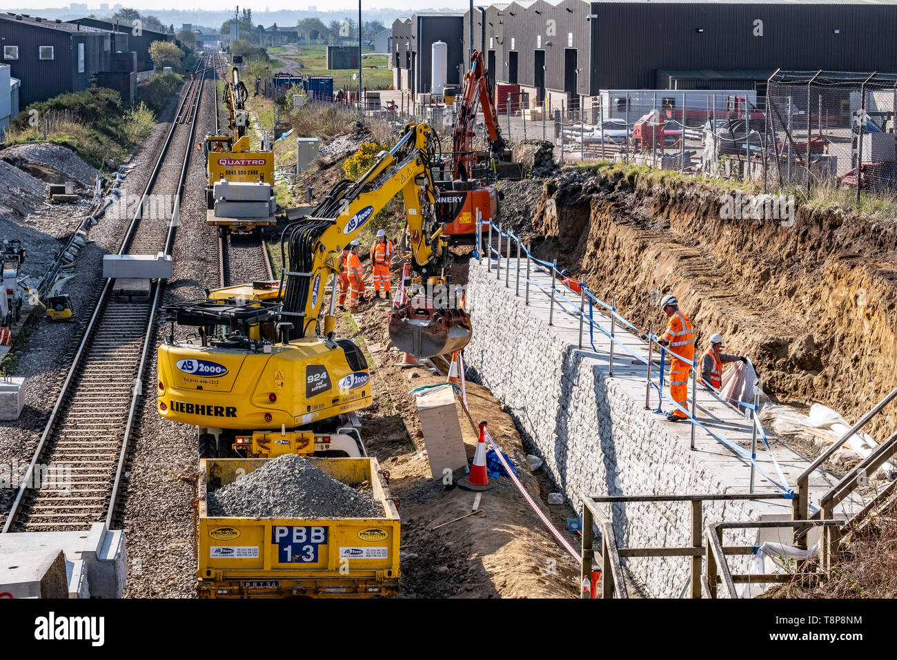 Railway workers constructing railway and lifting rail bridge into place ...