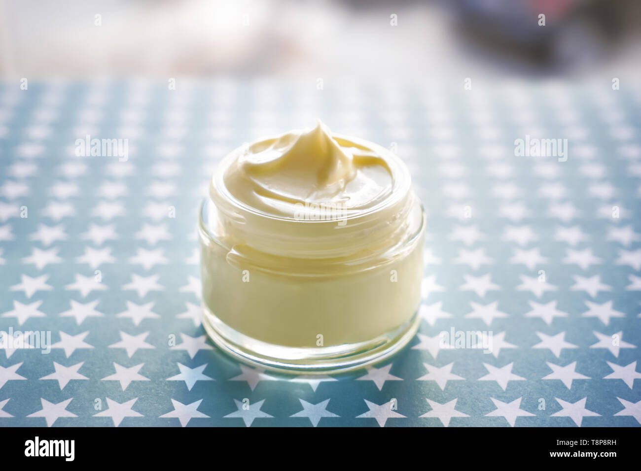 Jar with body cream on color table Stock Photo - Alamy