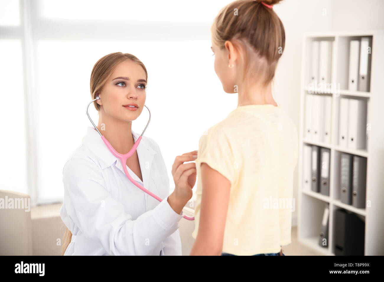 Female doctor examining little girl in clinic Stock Photo - Alamy
