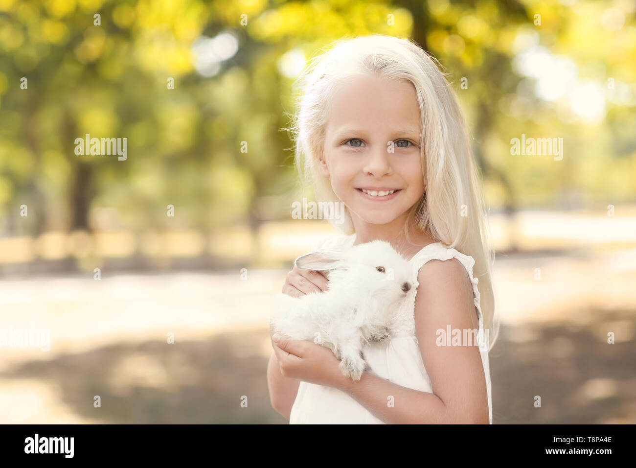 Little girl with cute rabbit outdoors Stock Photo - Alamy
