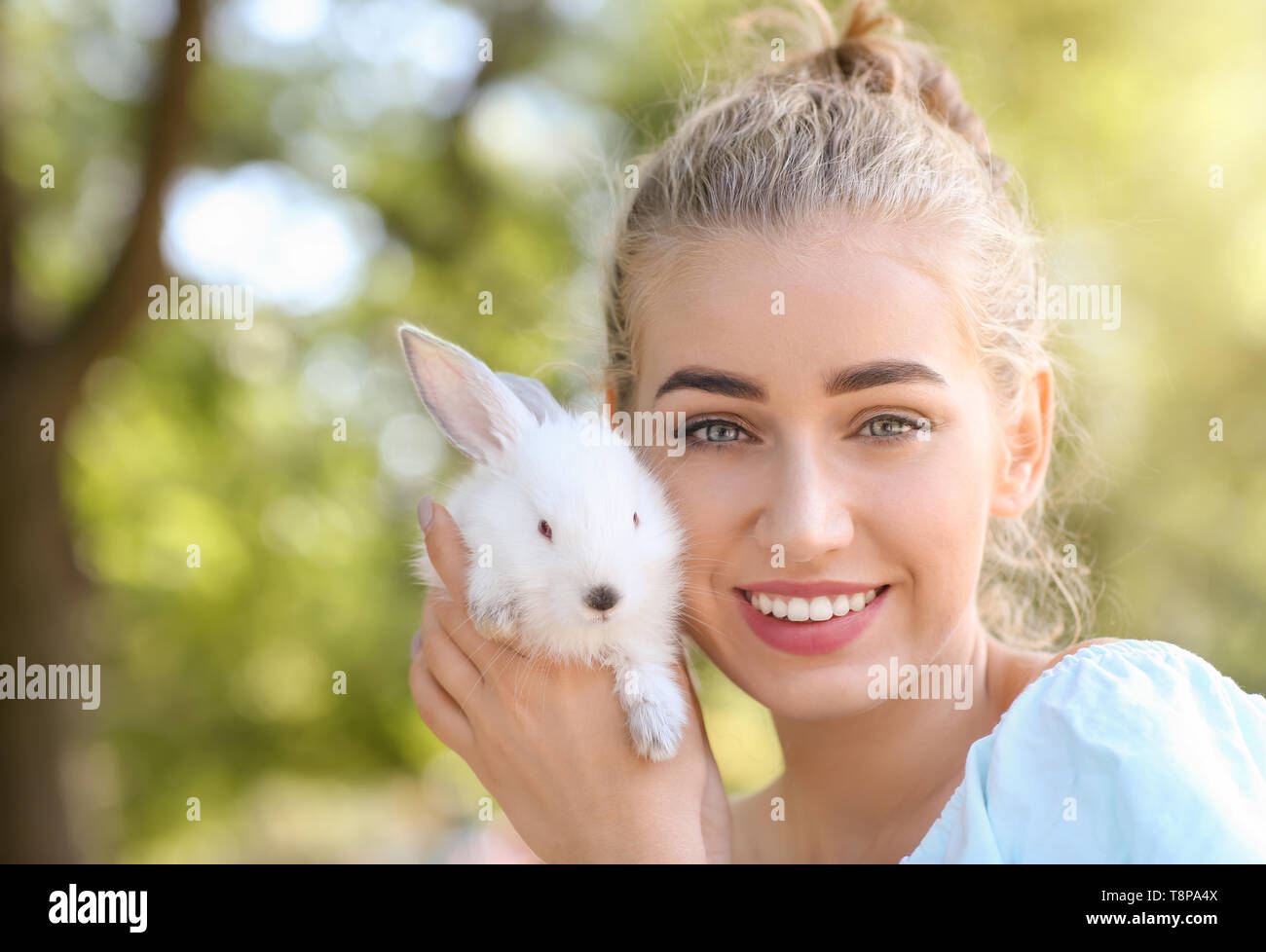 Beautiful young woman with cute rabbit outdoors Stock Photo - Alamy