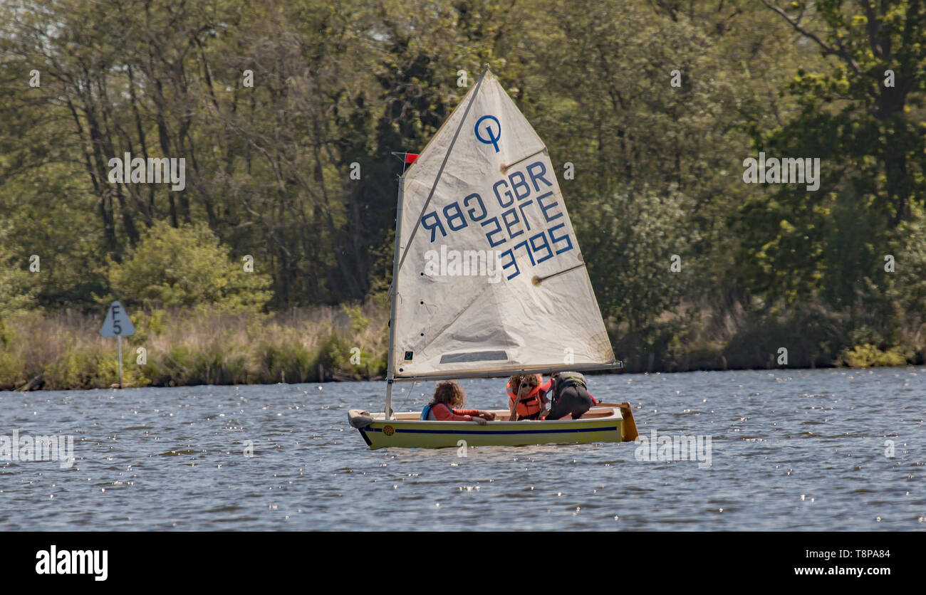 Sailing on Wroxham Broad in the Norfolk Broads. Three youngsters try ...