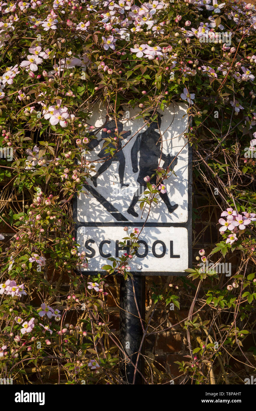 A traditional school sign surrounded and partially obscured by the ...