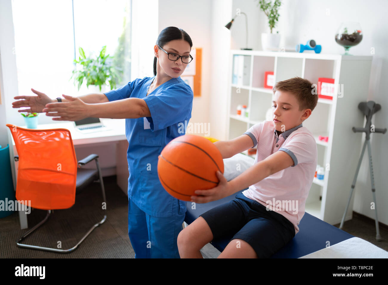 Attentive good-looking doctor in clear glasses giving instructions ...