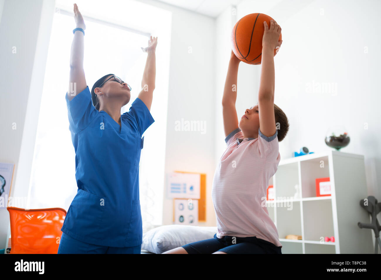 Active professional therapist showing right way of training Stock Photo ...