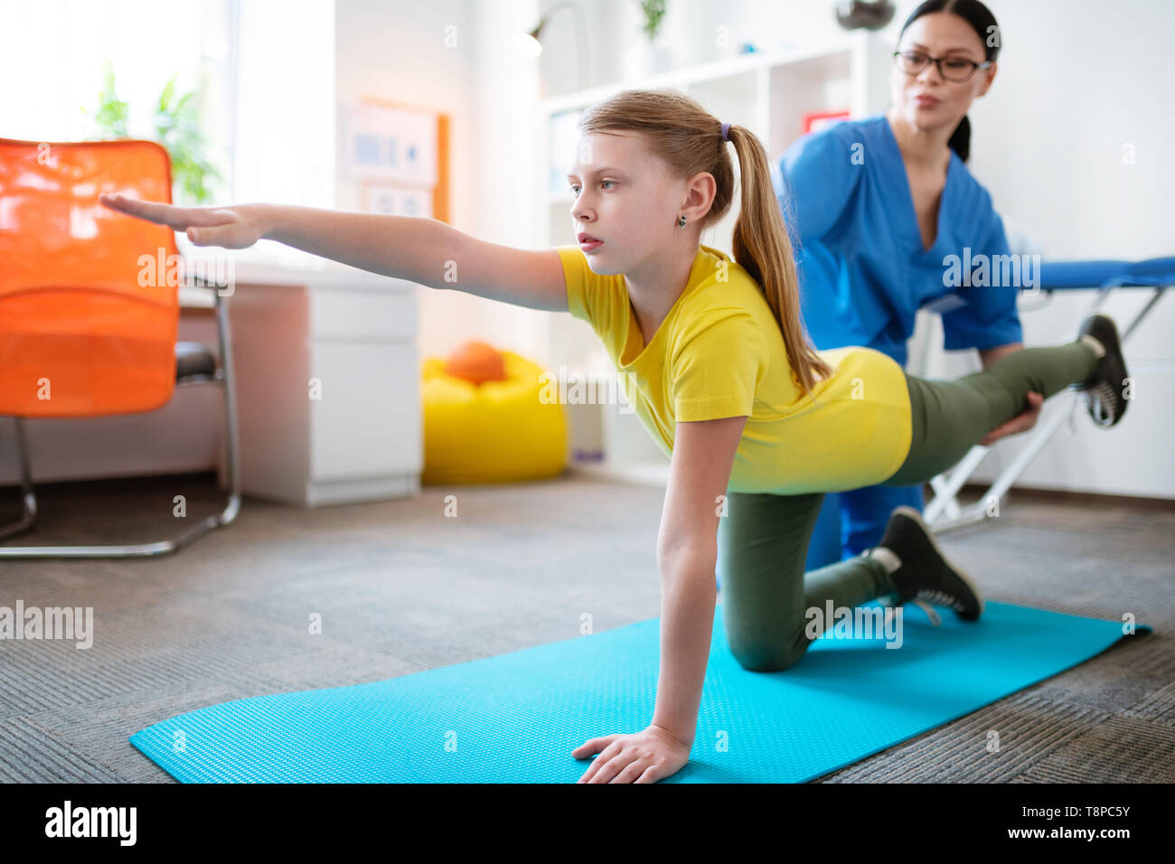 Emotionless tired girl pulling her hand and leg Stock Photo - Alamy