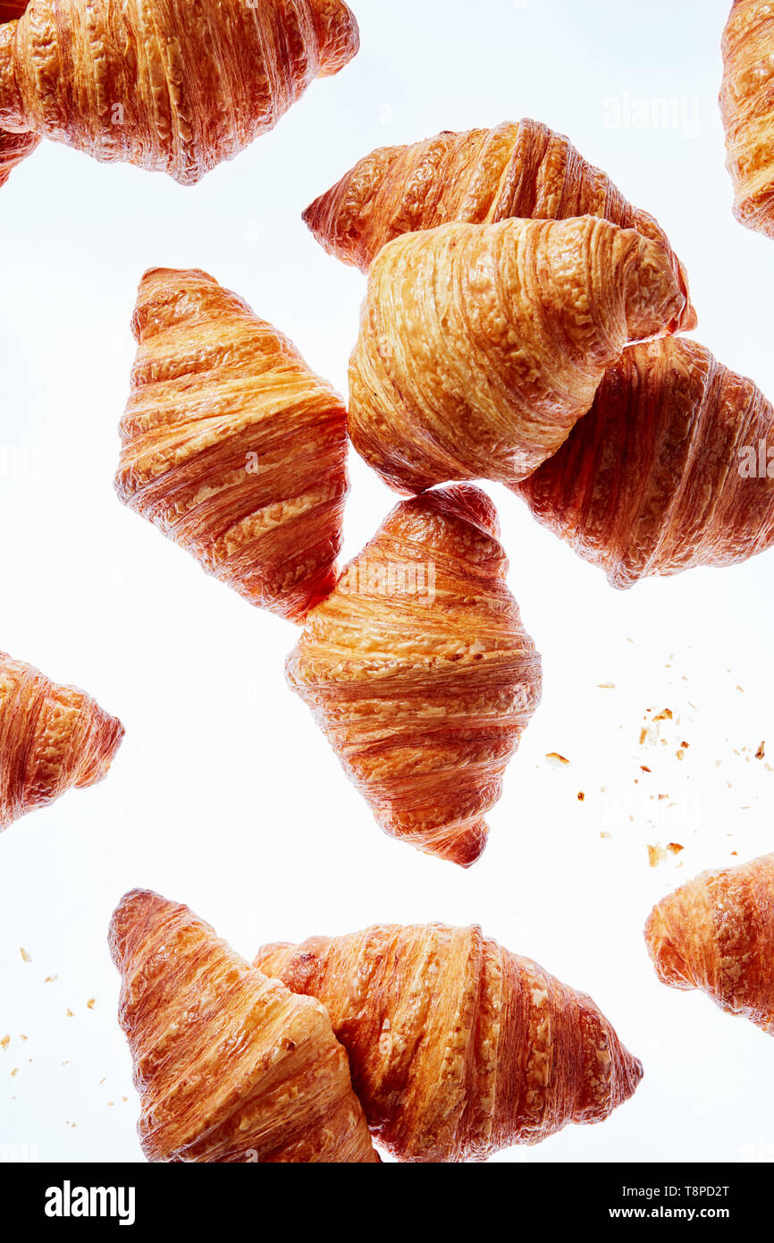 Falling fresh french croissants with crumbs on a light background Stock ...
