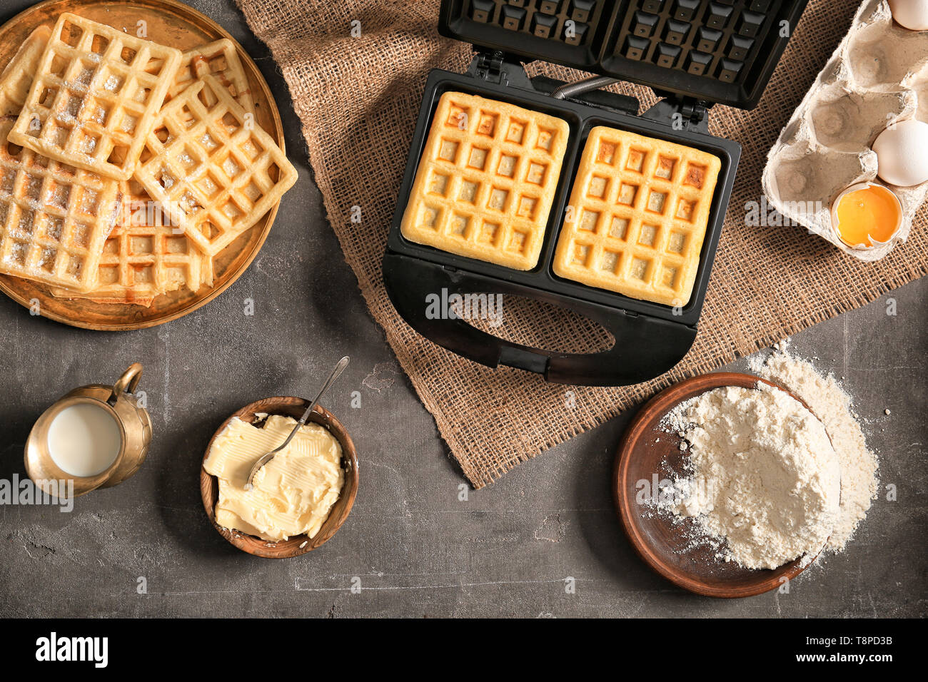 Modern waffle maker with ingredients on grey table Stock Photo - Alamy
