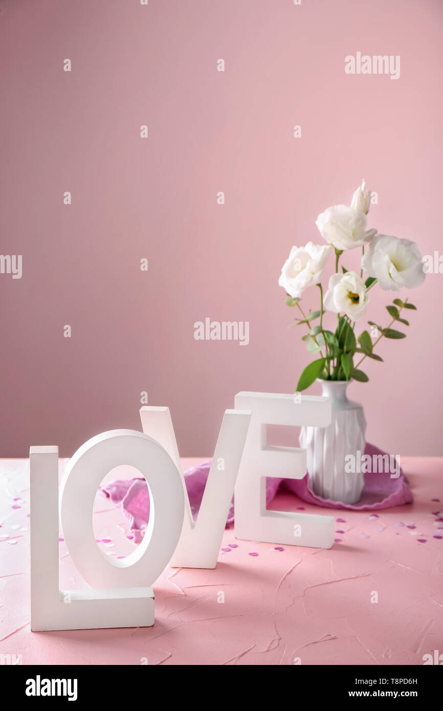 Word LOVE made of white letters on color table Stock Photo - Alamy