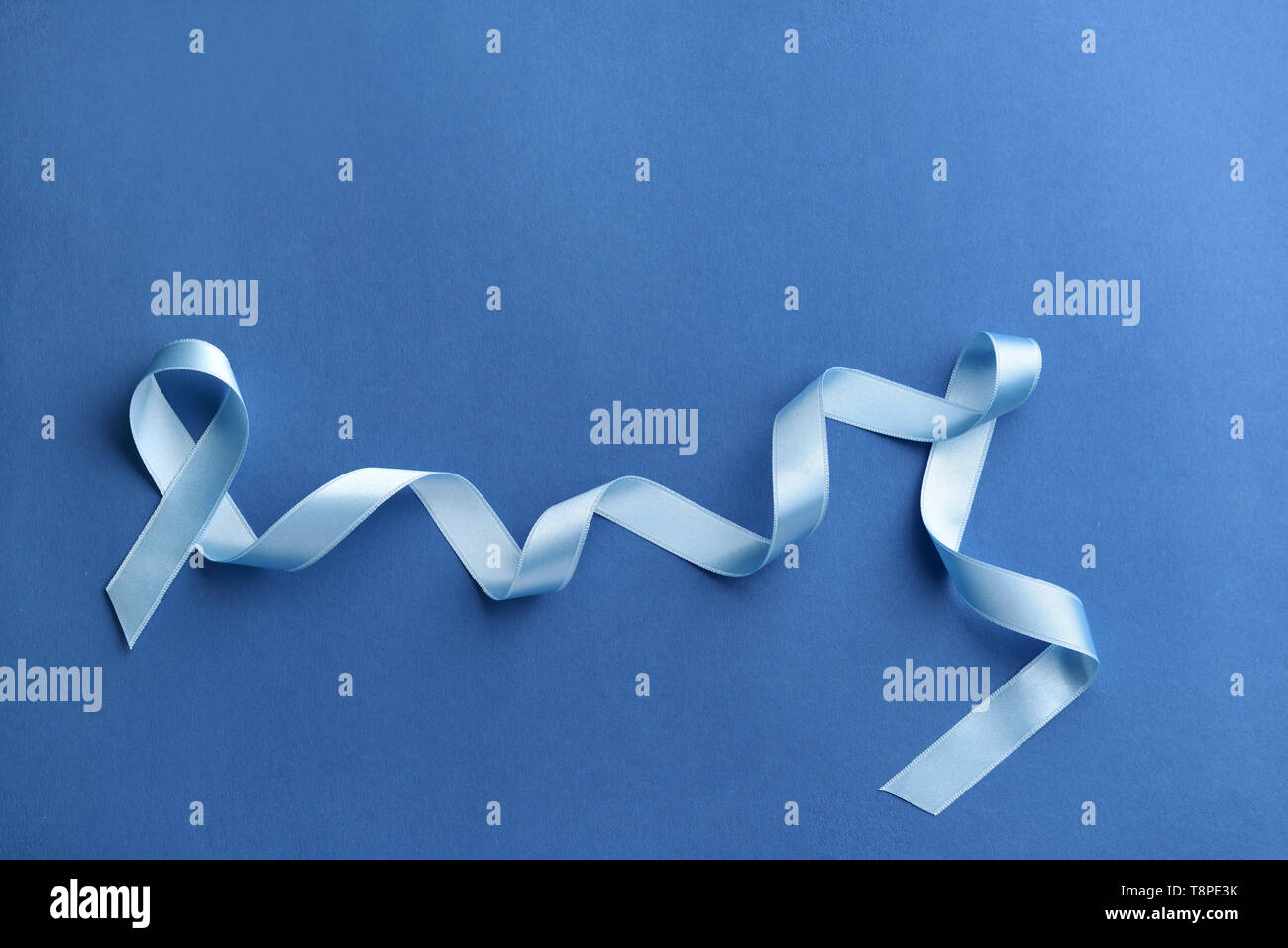 Blue ribbon on color background. Cancer concept Stock Photo - Alamy