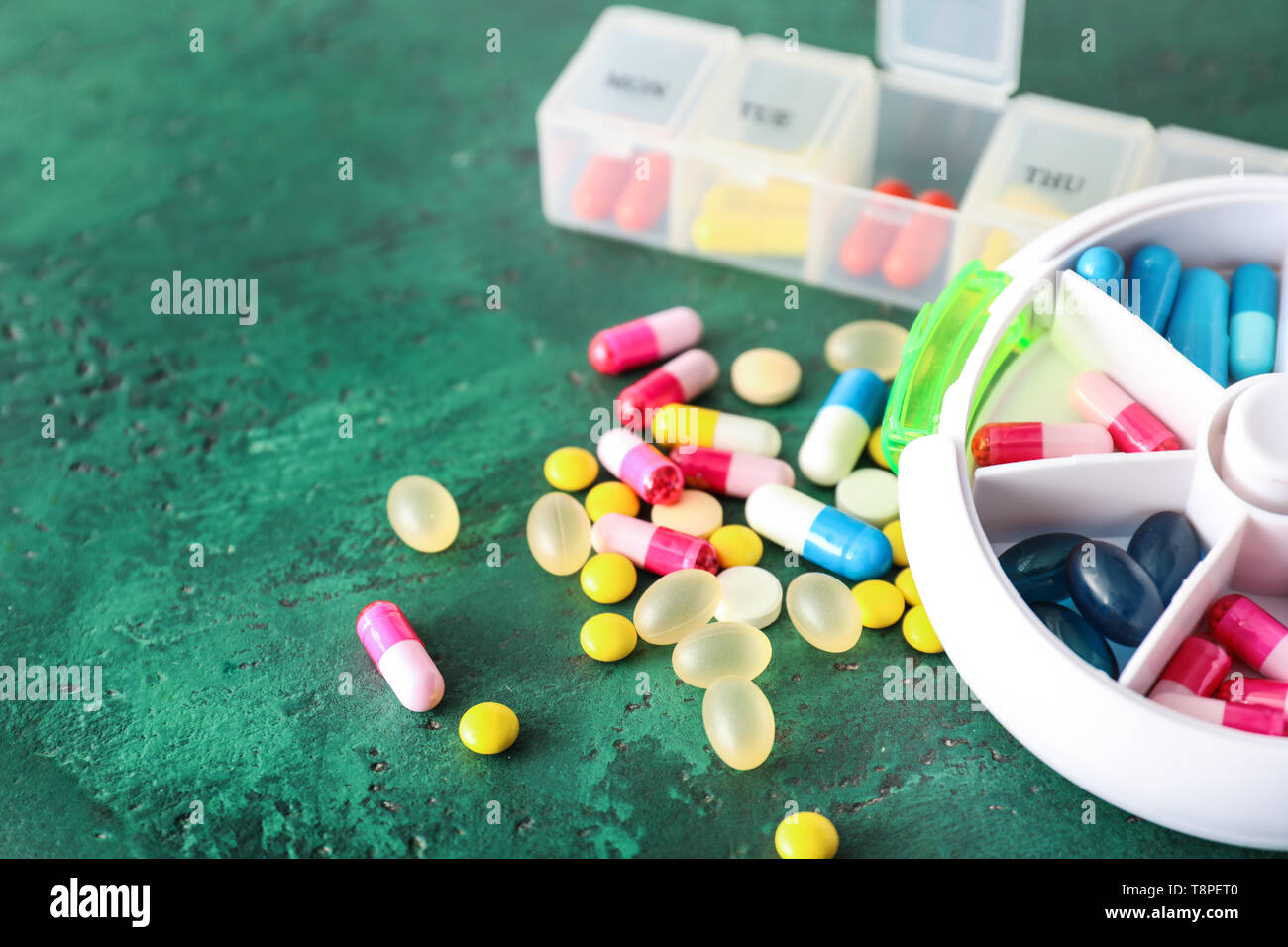 Plastic containers with pills on color table Stock Photo - Alamy