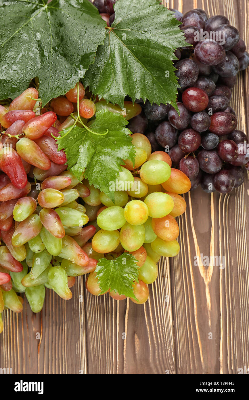 Different types of ripe sweet grapes on wooden background Stock Photo ...