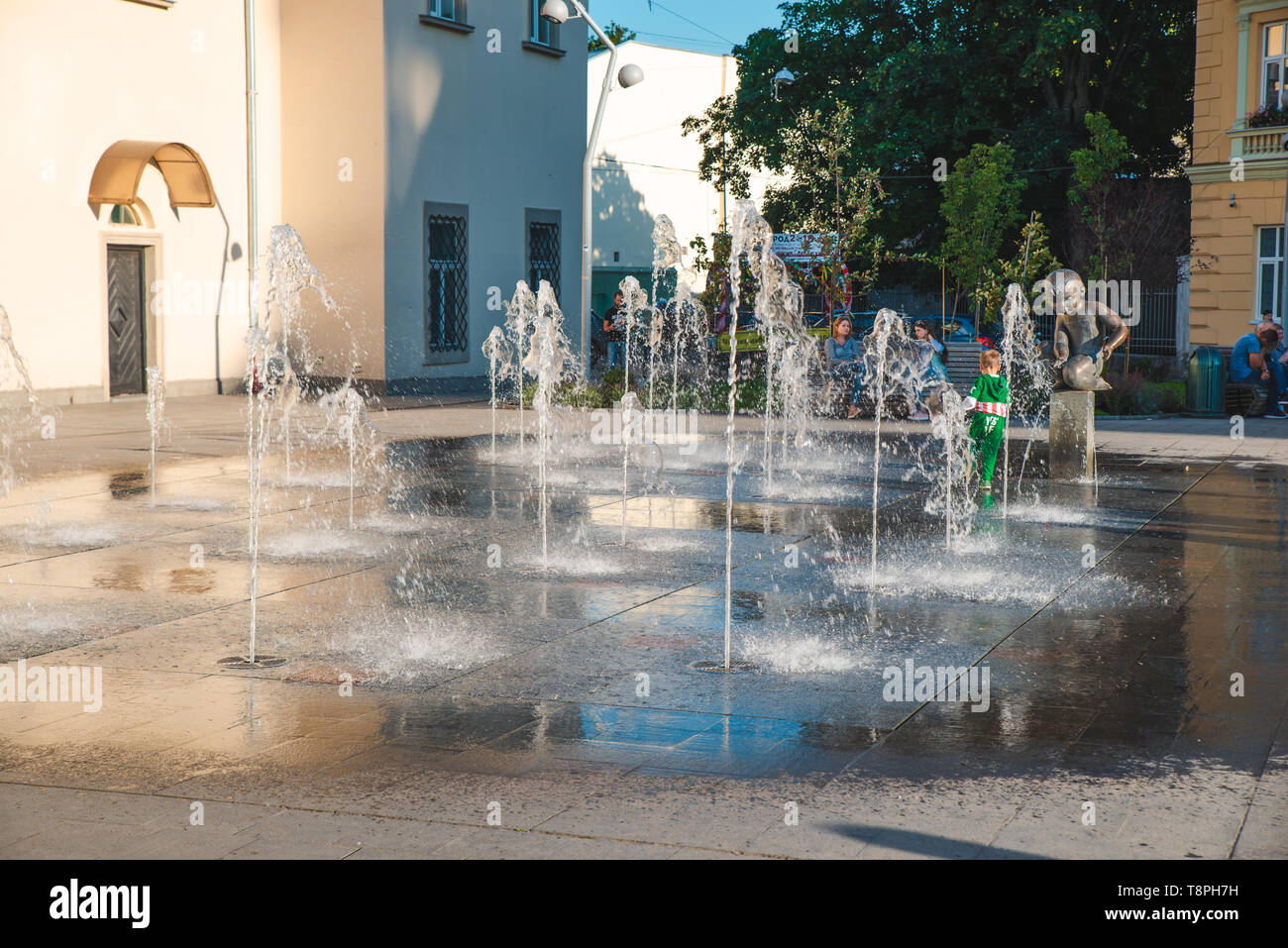 kids playing at city square near fountain. summer time Stock Photo - Alamy