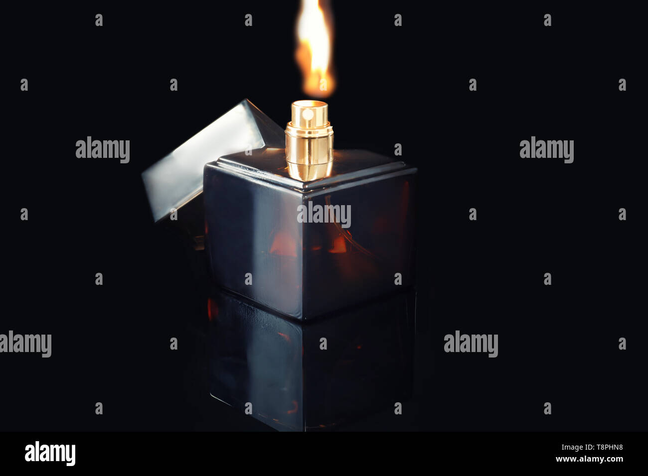 Bottle of perfume with flame on dark background Stock Photo - Alamy