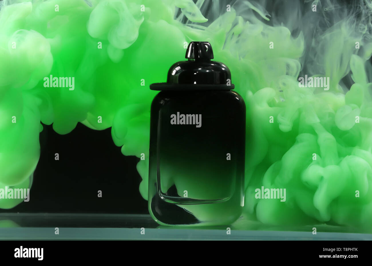 Bottle of perfume in color smoke on dark background Stock Photo - Alamy