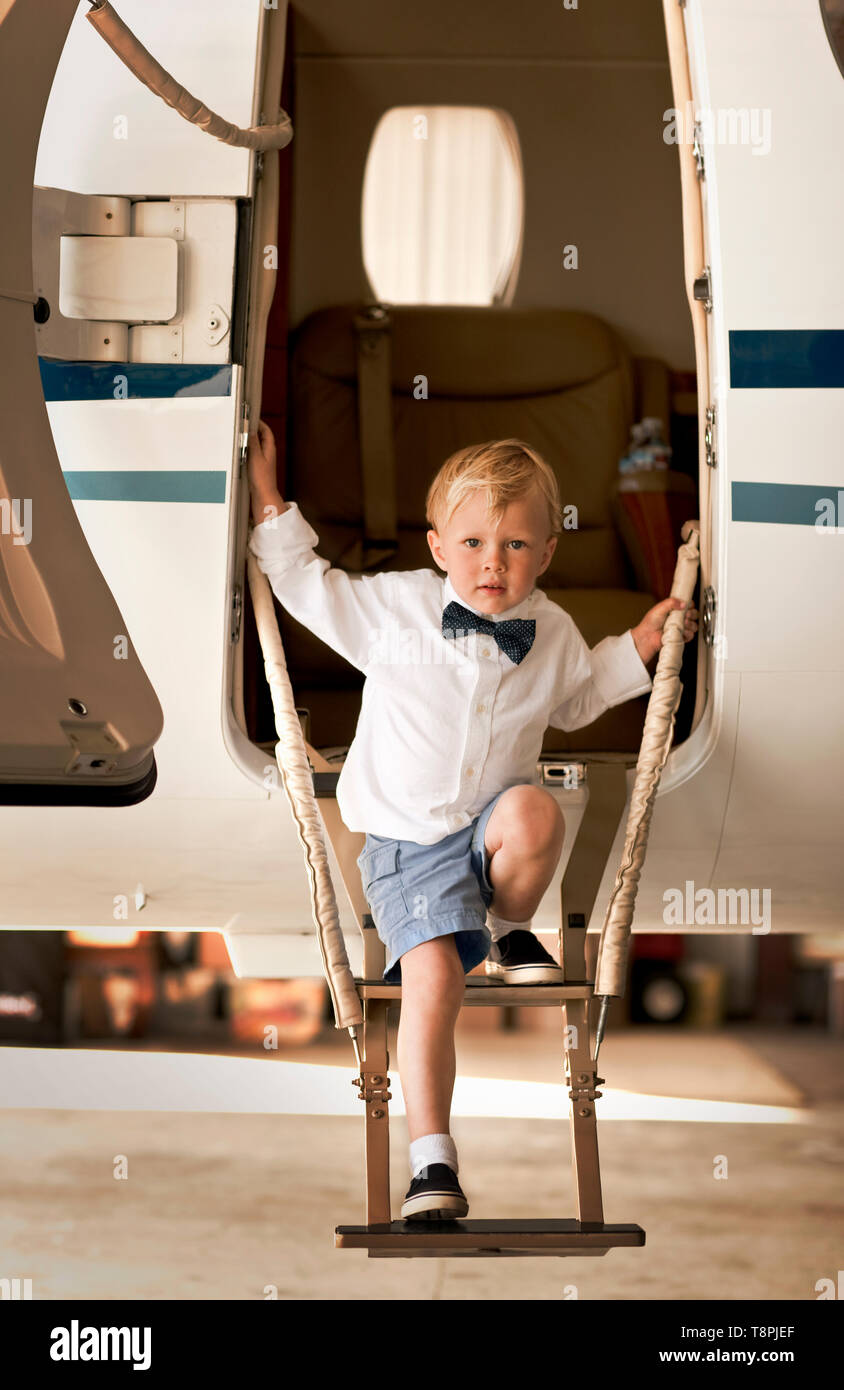 A young boy stepping out of an airplane Stock Photo - Alamy