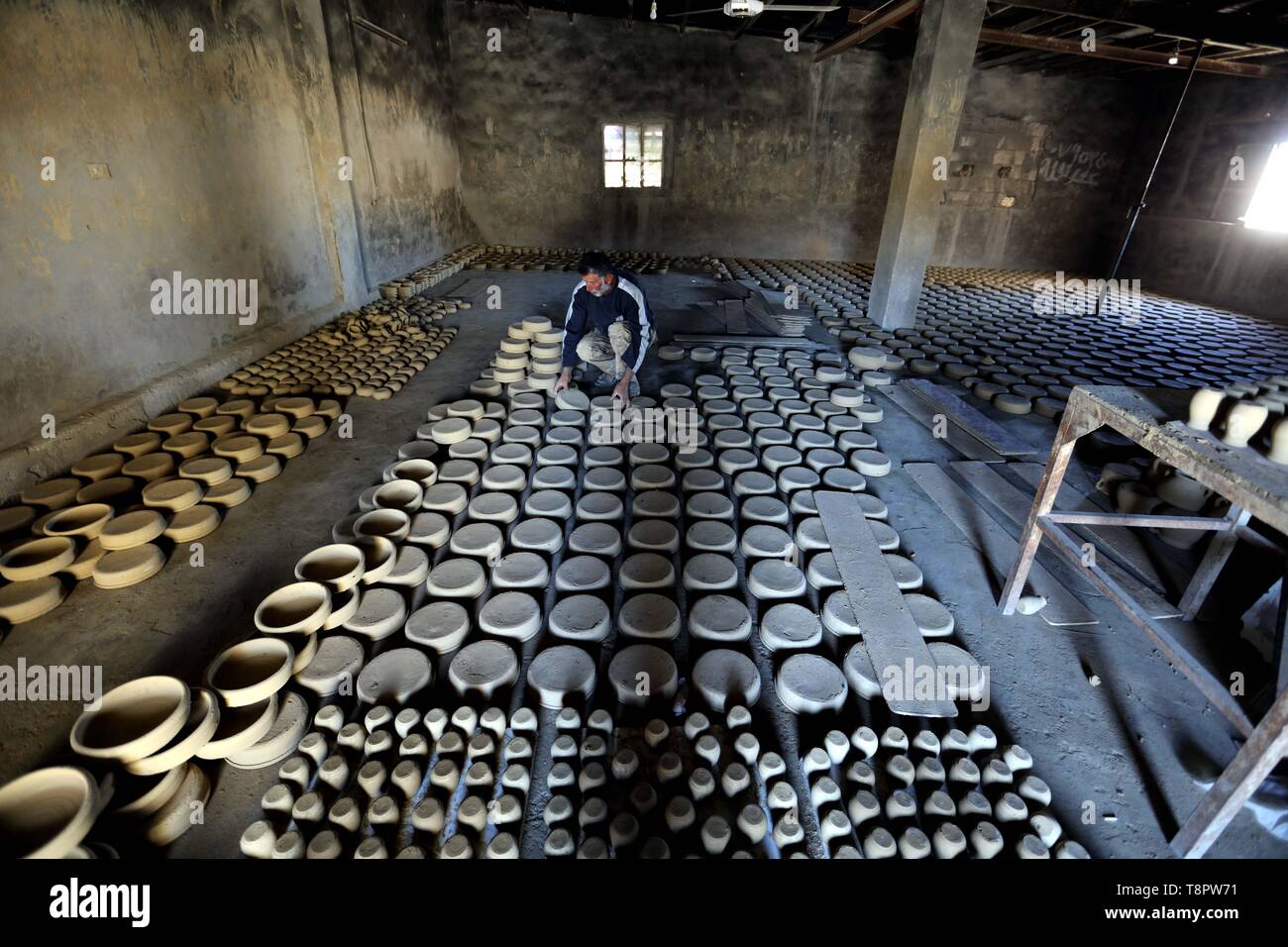 Amman, Jordan. 14th May, 2019. A Jordanian craftsman arranges pottery ...